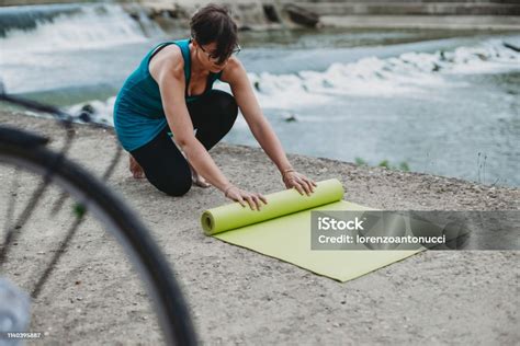 젊은 아름 다운 여자는 강의 은행에 여름에 요가 연습을 할 지상에 매트를 정렬 강에 대한 스톡 사진 및 기타 이미지 강 건강한 생활방식 공원 Istock