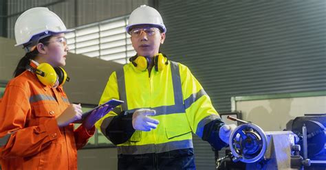 엔지니어 협력 두 명의 아시아 유지 보수 엔지니어 남녀가 태블릿 장치로 릴레이 보호 시스템을 검사하여 품질 관리 프로세스 작업을 제어하고 중공업 제조 공장 사진