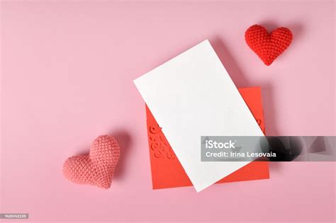 분홍색 배경에 빈 시트와 두 개의 니트 하트가있는 빨간 봉투의 모형 2월에 대한 스톡 사진 및 기타 이미지 2월 결혼식 공란 Istock