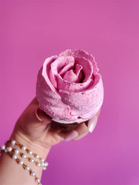 분홍색 배경에 분홍색 젖빛 컵케이크를 들고 있는 손 사진 Unsplash의 무료 아름다운 배경 이미지 이미지
