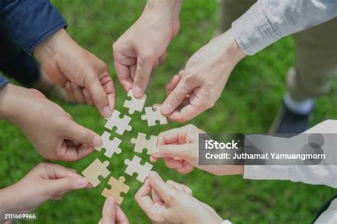 푸른 잔디밭에서 하루 종일 퍼즐 조각을 들고 있는 팀워크 동료의 클로즈업 손 사업가 텍스트 사용을 위한 퍼즐 복사 공간 팀 컨셉 상의 View 공동체에 대한 스톡 사진 및