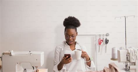 앞치마를 두른 쾌활한 여성 재봉사가 전화로 이야기하고 커피를 마신다 사진 Unsplash의 한 명의 여성만 이미지