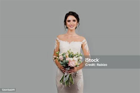 웨딩 꽃다발 미소와 신부 카메라에서 보이는 그녀의 얼굴을 만진다 소셜 네트워크에 대한 매력적인 소녀 초상화 빈 배경에 웨딩