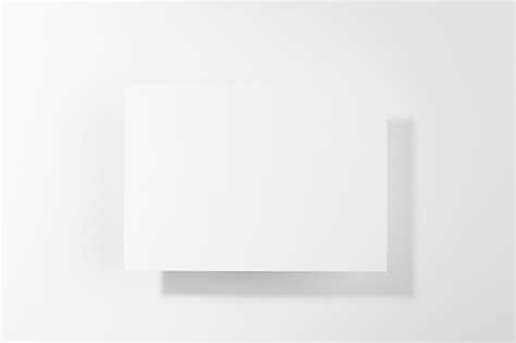 그림자가있는 하드 라이트에서 텍스트 모형을위한 흰색 빈 카드가 부드러운 밝은 흰색 배경에 치솟습니다 광고 브랜딩 정체성 인사말 카드 포스터 디자인 전단지를위한 간단한 현대