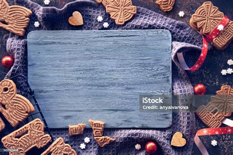 Speculoos 또는 Spekulatius 어두운 질감의 배경에 크리스마스 비스킷 독일 전통 과자 크리스마스 쿠키 복사 공간이 있는 질감 있는 도마 주변의 축제 프레임