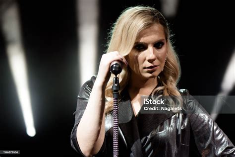 긴 머리를 한 여성 가수가 스탠드와 함께 마이크를 들고 노래를 부른다 Fashion Show에 대한 스톡 사진 및 기타 이미지