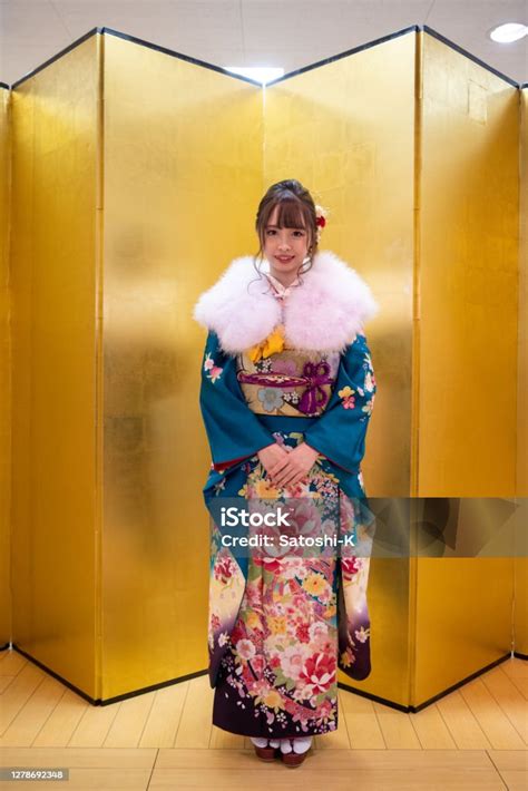 세이진시키 성년의식 용 황금 바이오부 접이식 스크린 앞에 모피 목을 훔친 후리소드 기모노를 입은 젊은 여성의 전체 길이 초상화 일본 민족에 대한 스톡 사진 및 기타 이미지