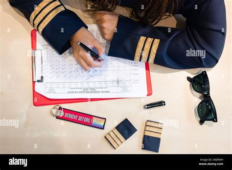 Unrecognizable Female Pilot Preparing Flight Documentation With A
