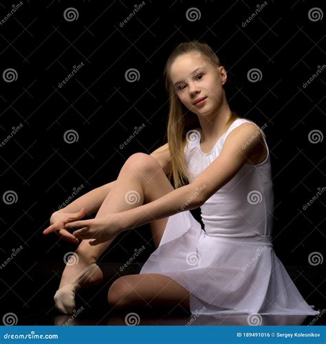 Of Lovely Preteen Girl Sitting On The Floor Hugging Her Knees Stock