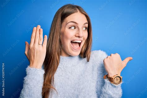 Young Beautiful Redhead Woman Wearing Wedding Ring On Finger Over Blue