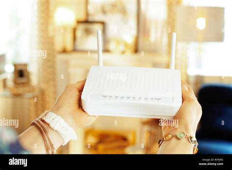 Closeup On Modern Wifi Router With Antennas In Hand Of Modern Woman In The Living Room Stock