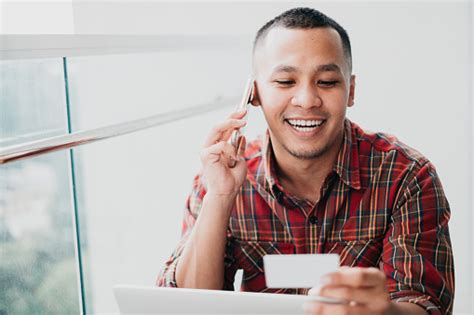 테이블에 노트북과 신용 카드를 들고 고객 서비스를 호출 하는 젊은 아시아 남자 25 29세에 대한 스톡 사진 및 기타 이미지 25 29세 고객 서비스 담당자 기업