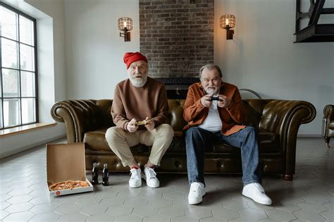 갈색 스웨터 거실 게이밍 게임 컨트롤러 게임 콘솔 겨울 실내 기술 남자 낮 노인 놀이 늙은 남성 라이프스타일 레저 레크리에이션 미소 벽돌 벽