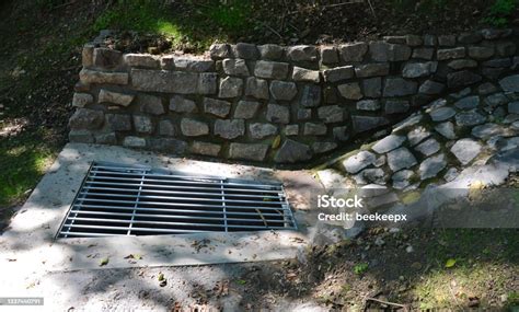 U자 형 콘크리트 배수로에서 거친 더 큰 먼지 조각을 잡는 대형 금속 그릴로 덮인 하수 맨홀 고속도로 배수 숲 경로에 시크레볼트 옹돌벽 거리에 대한 스톡 사진 및 기타