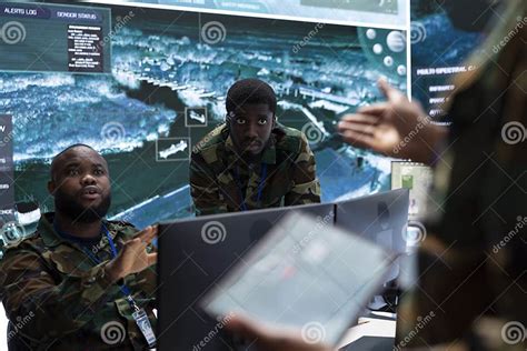 Army Professionals In Command Post Overseeing Satellite Data And Surveillance Stock Image