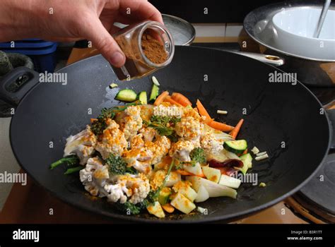 Putting Curry On Vegetables Stock Photo Alamy