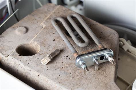 The Electric Heating Element And Temperature Sensor Thermostat Are On The Disassembled Washing