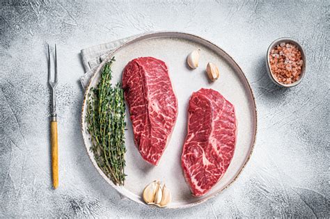 생 굴 탑 블레이드 또는 허브와 접시에 플랫 철 로스트 쇠고기 고기 스테이크 흰색 배경입니다 맨 위 보기 목정에 대한 스톡 사진 및 기타 이미지 Istock