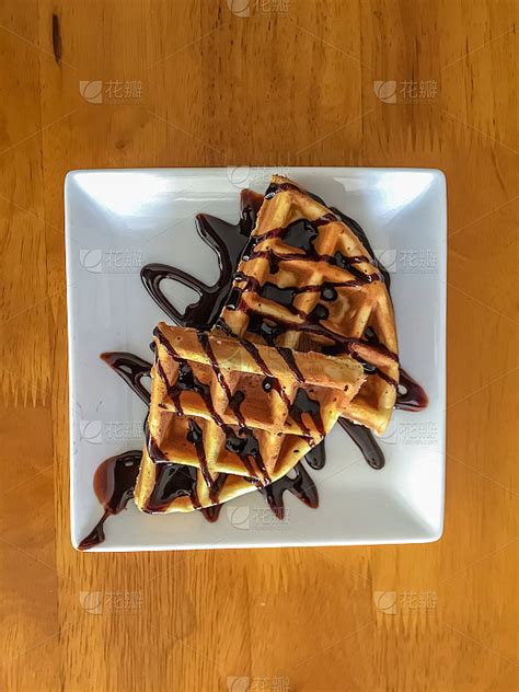 木桌上放着巧克力酱华夫饼俯视图