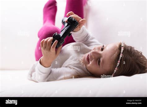 Kleines Mädchen Auf Dem Rücken Auf Einem Bett Mit Einer Video Game
