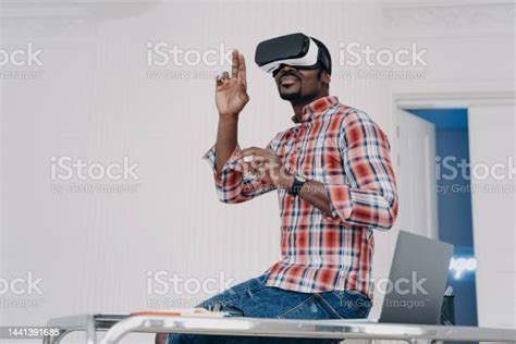 가상 현실 안경의 아프리카 계 미국인 남자 소프트웨어 개발자는 앱을 만들고 사무실 책상에 앉아 있습니다 30 34세에 대한 스톡