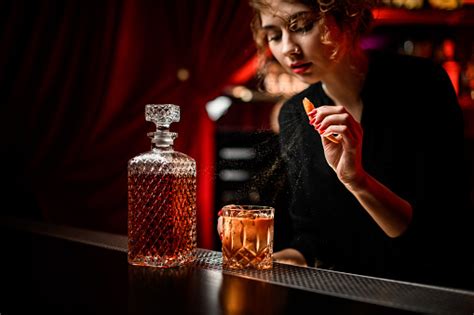 여성 바텐더는 바 카운터에 차가운 알코올 칵테일을 곁들인 유리에 조심스럽게 뿌려 캄파리에 대한 스톡 사진 및 기타 이미지 캄