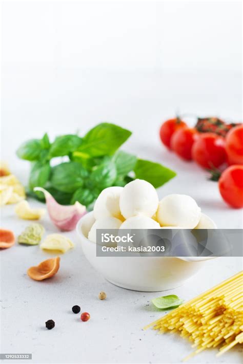 파스타 토마토 마늘 올리브 오일 모짜렐라 치즈 볼 바질 등 이탈리아 요리의 전통적인 유기농 재료로 밝은 회색 슬레이트 돌 또는 콘크리트 배경 개체 그룹에 대한 스톡 사진 및