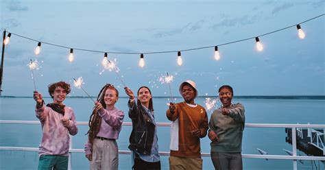 반짝이는 벵골 불빛을 가진 행복한 젊은 다인종 사람들이 부두에서 야외 파티를 즐기고 있다 사진 Unsplash의 휴식 이미지