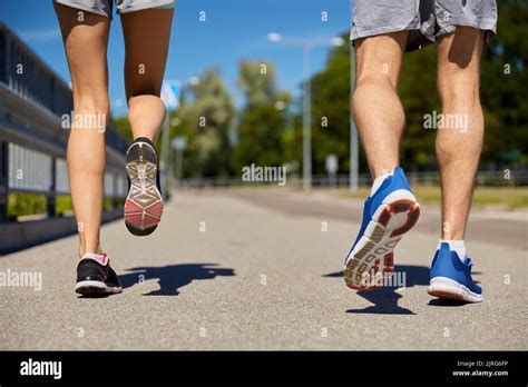 Feet Of Sporty Couple Running Along City Road Stock Photo Alamy