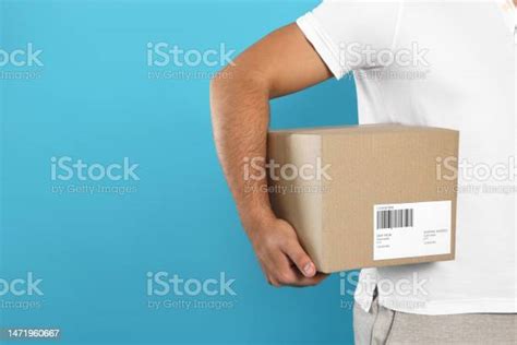 밝은 파란색 배경에 골판지 상자를 들고 있는 택배 근접 촬영 텍스트를 위한 공간 소포에 대한 스톡 사진 및 기타 이미지 소포 스튜디오 촬영 우체부 Istock