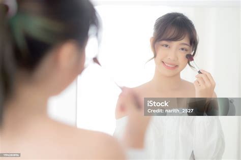 침실에 브러쉬 뺨으로 메이크업을 적용 얼굴을 찾고 거울 블러셔 스킨 케어 및 화장품 테이블 패션 개념을 들고 아름다운 여자와 미소 뷰티 초상화 젊은 아시아 여성 귀여운에