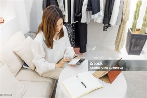 스타트업 중소기업 스마트폰 이나 태블릿을 사용 하 여 젊은 중국 여자 기업가 수신 하 고 온라인 구매 쇼핑 주문을 확인 팩 제품 상자를 준비 하 고 있습니다 온라인 판매