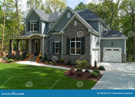 Suburban House With Stone Exterior And Green Lawn In An Affluent