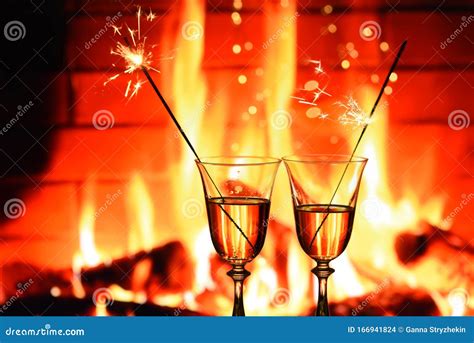Two Glasses With Sparkling Champagne Wine On A Burning Fire In A