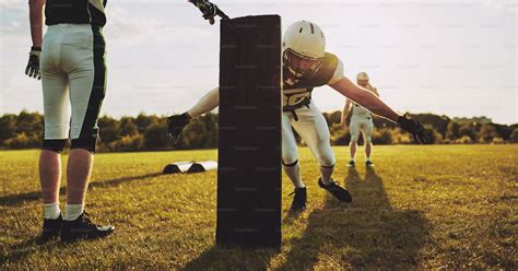 오후에 잔디밭에서 함께 태클과 수비 훈련을 연습하는 젊은 미식 축구 선수들 사진 Unsplash의 대학 미식축구 이미지