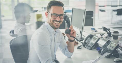 백인 사업가가 유선 전화로 대화를 나누고 있다 사무실에 있는 사업가 카메라를 보고 있습니다 사진 Unsplash의 통화 이미지