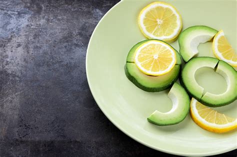 아침 식사에 대 한 아보카도 녹색 접시 어두운 빈티지 배경 채식주의 음식 건강 한 자연 식품 열 대 과일 아보카도 레몬 Sliced 공간 복사 감귤류 과일에 대한 스톡 사진