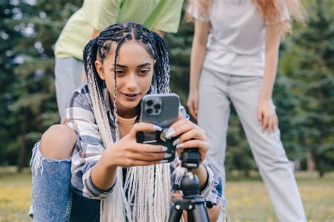 조이라이드 중에 자기 사진을 찍고 싶어하는 스탠드에 전화를 고정하려고하는 힙스터 소녀 비디오 블로그를 촬영하는 영향력있는 사람 즐거운 시간을 보내는 젊은 친구들 십대에 대한