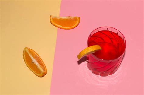 레몬과 오렌지 조각으로 장식 된 딸기 주스 파스텔 옐로우 핑크 배경에 즐거운 여름 다과 창조적 인 여름 컨셉 0명에 대한 스톡