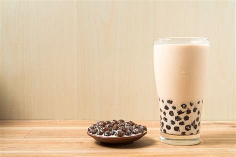 유리 잔의 진주 우유 차 와 나무 배경에 타 피 오카 볼의 접시 진주 밀크 티는 대만에서 가장 대표적인 음료입니다 대만 음식 복사 공간이 있습니다 각얼음에 대한 스톡 사진