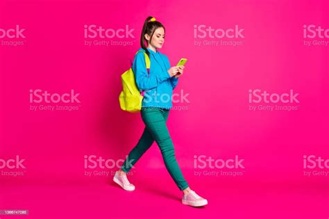 사랑스러운 젊은 아가씨착용 블루 스웨터 배낭 걷기 현대 장치 고립 된 밝은 분홍색 색상 배경을 착용하는 전체 길이 사진 분홍색 배경에 대한 스톡 사진 및 기타 이미지