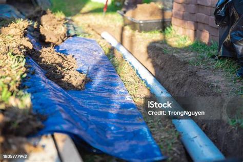 집 배수 시스템 설치의 측면 Pvc 파이프 지상 트렌치에 묻혀 파란색 방수포 흙 점토 토양 주거용 주택 달라스 텍사스 미국에