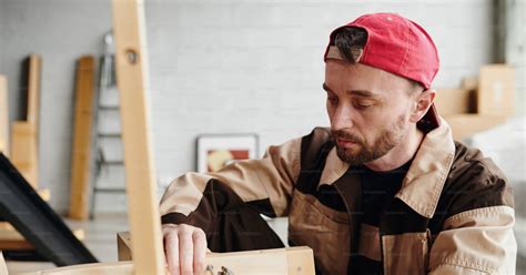 큰 새 집 아파트 또는 스튜디오에서 조립하는 동안 의자의 부품을 고정하는 작업복의 심각한 젊은 가구 조립 전문가 사진 Unsplash의 보호 작업복 이미지