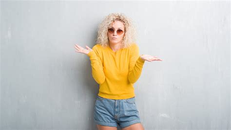 그런 지 회색 배경 우 둔 하 고 혼란 스 러 워 식으로 발생 하는 손과 팔에 곱슬 머리 젊은 금발 여자 의심 개념입니다 감정에 대한 스톡 사진 및 기타 이미지 Istock