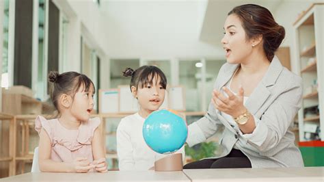 초등학생과 미취학 아동들은 몬테소리 교육 학교에서 교사와 함께 모형 지구본으로 세계 지도를 배우고 있다 3차원 형태에 대한 스톡 사진 및 기타 이미지 Istock