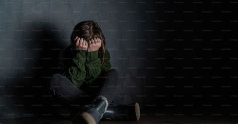 어둠 속에서 홀로 앉아 얼굴을 가리고 있는 슬픈 어린 소녀 사진 Unsplash의 슬로바키아 이미지