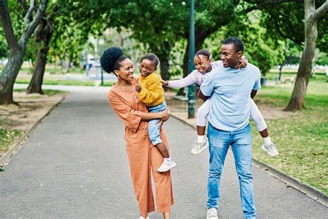 흑인 가족의 즐거움 공원 산책 야외 돼지 등을 엄마 아버지 아이들과 함께 정원 경로로 즐길 수 있습니다 부모 사랑 아이들은 행복과 부모의 지원을 느끼는 휴일에 어머니와 함께