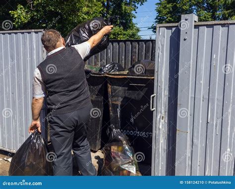 A Man Throws Plastic Bags With Garbage In A Container Editorial Image Image Of City
