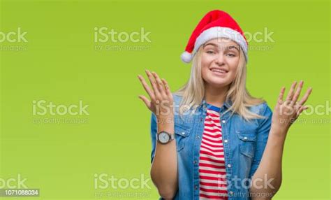 젊은 백인 여자에 크리스마스 모자를 쓰고 배경 축 제기 및 닫힌 눈 비명 흥분 하는 무기와 성공을 위해 미친 미친 하 고립