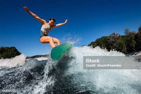 밝은 서핑 보드와 회색 수영복 점프에 행복한 여자 웨이크 서퍼 서핑 수상 스포츠에 대한 스톡 사진 및 기타 이미지 서핑 수상 스포츠 한 명의 여자만 여성 Istock